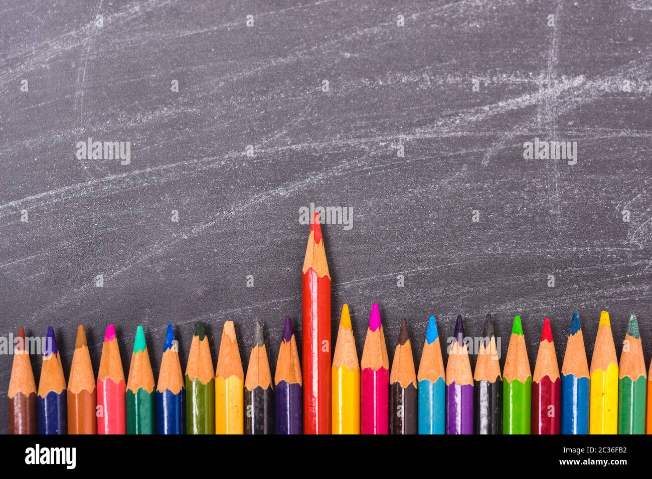 Red pencils color standing out from the crowd on blackboard and have ...