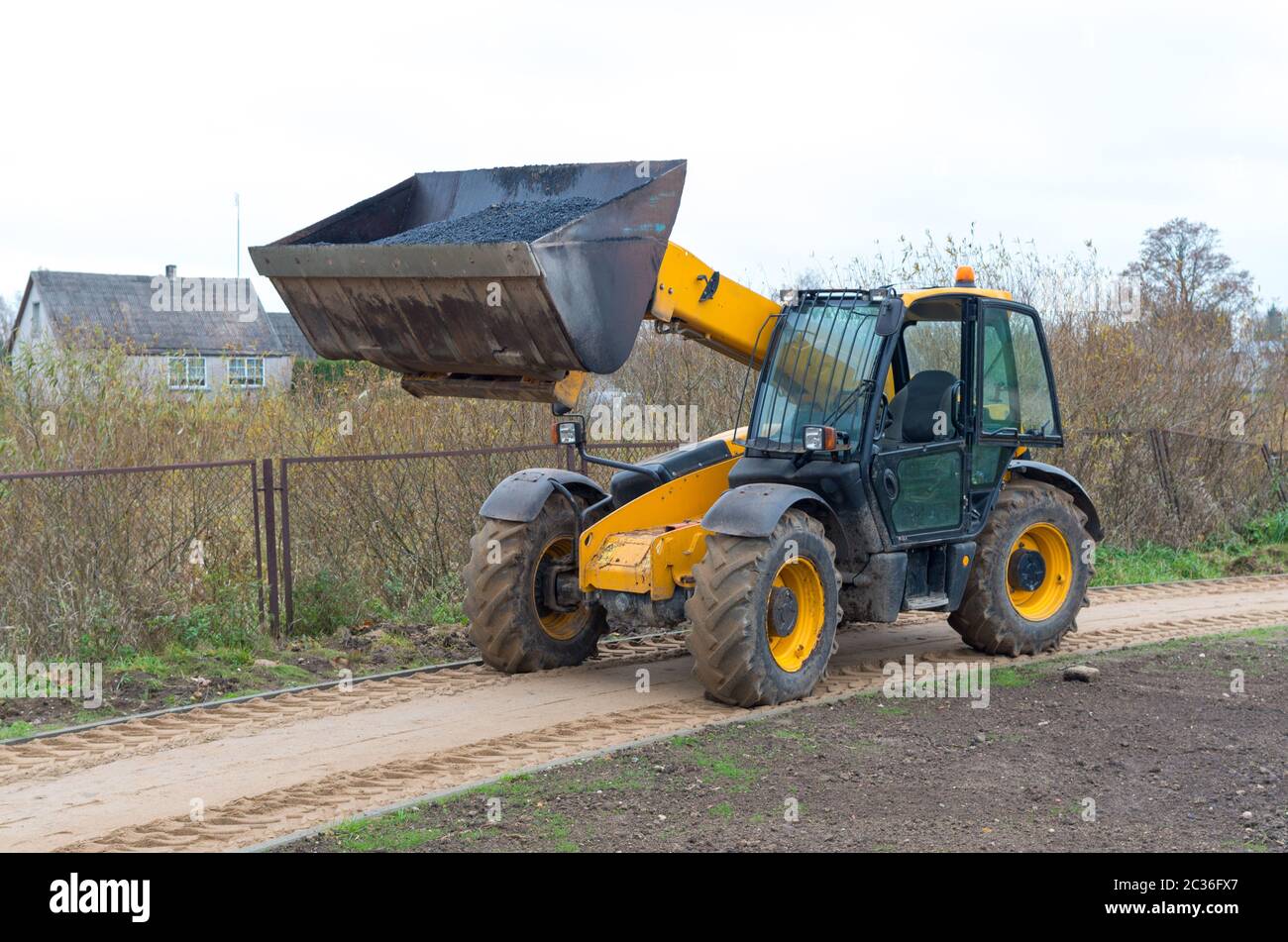 Front loader in action. The hoist raised Stock Photo - Alamy