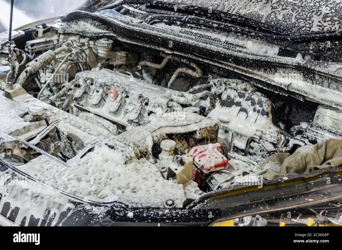 Wash the car engine with foam, car wash foam Stock Photo - Alamy