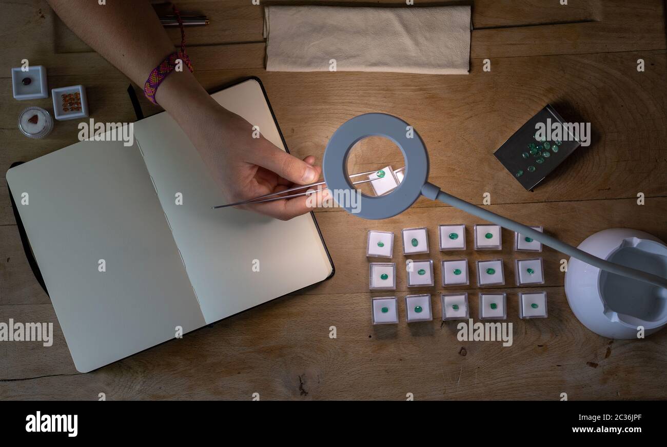Top view of a gemologist's work table, observing gemstones with a ...