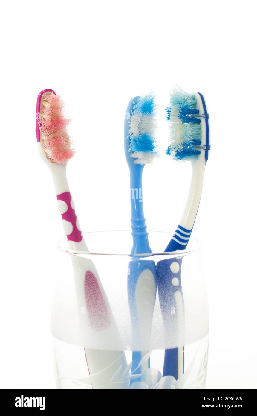 old used colorful toothbrushes in a glass Stock Photo - Alamy