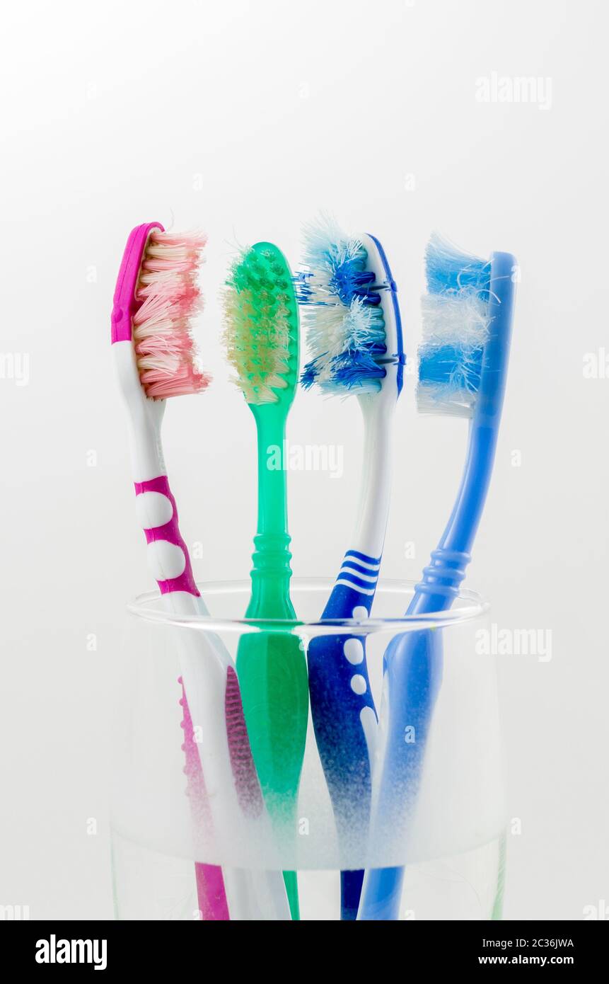 old used colorful toothbrushes in a glass Stock Photo - Alamy