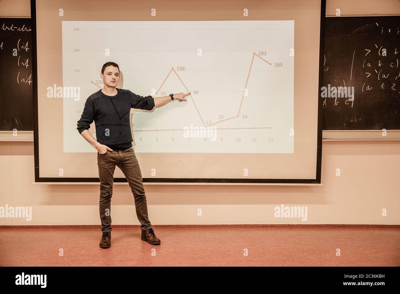 man, student showing a graph on a projection board while teaching at ...