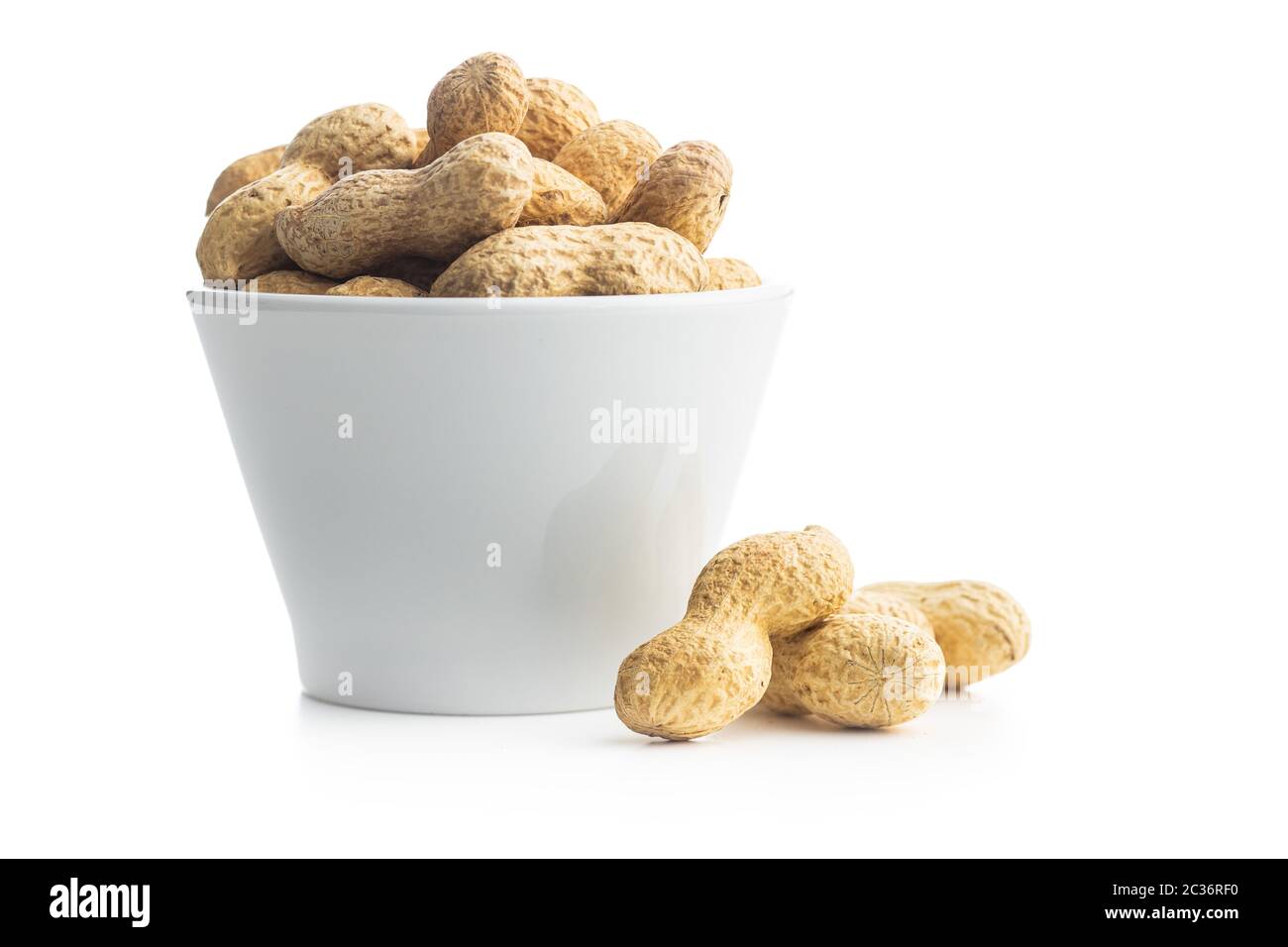 Tasty unpeeled peanuts in bowl isolated on white background Stock Photo ...