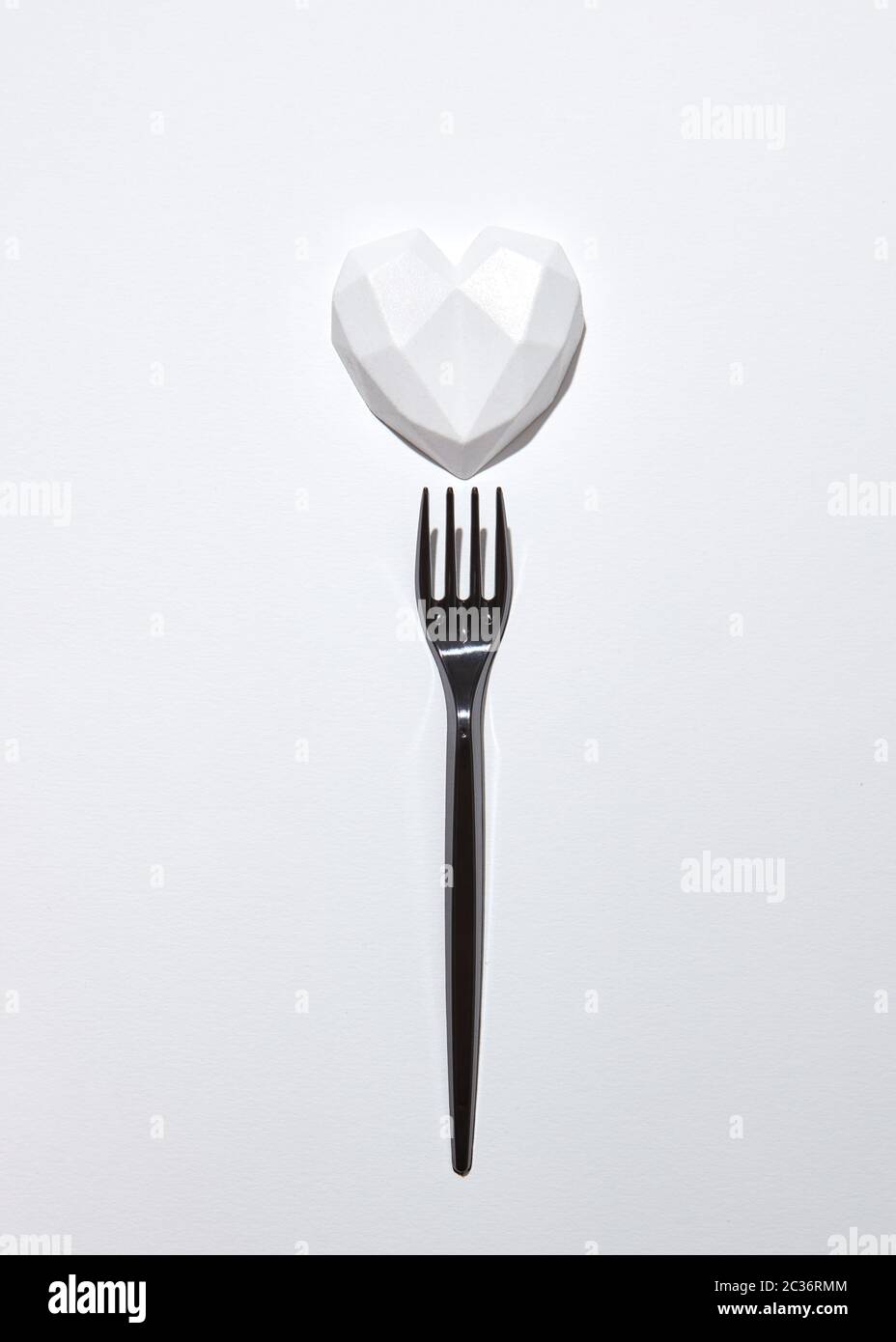 Black plaster fork with gypsum white heart Stock Photo - Alamy