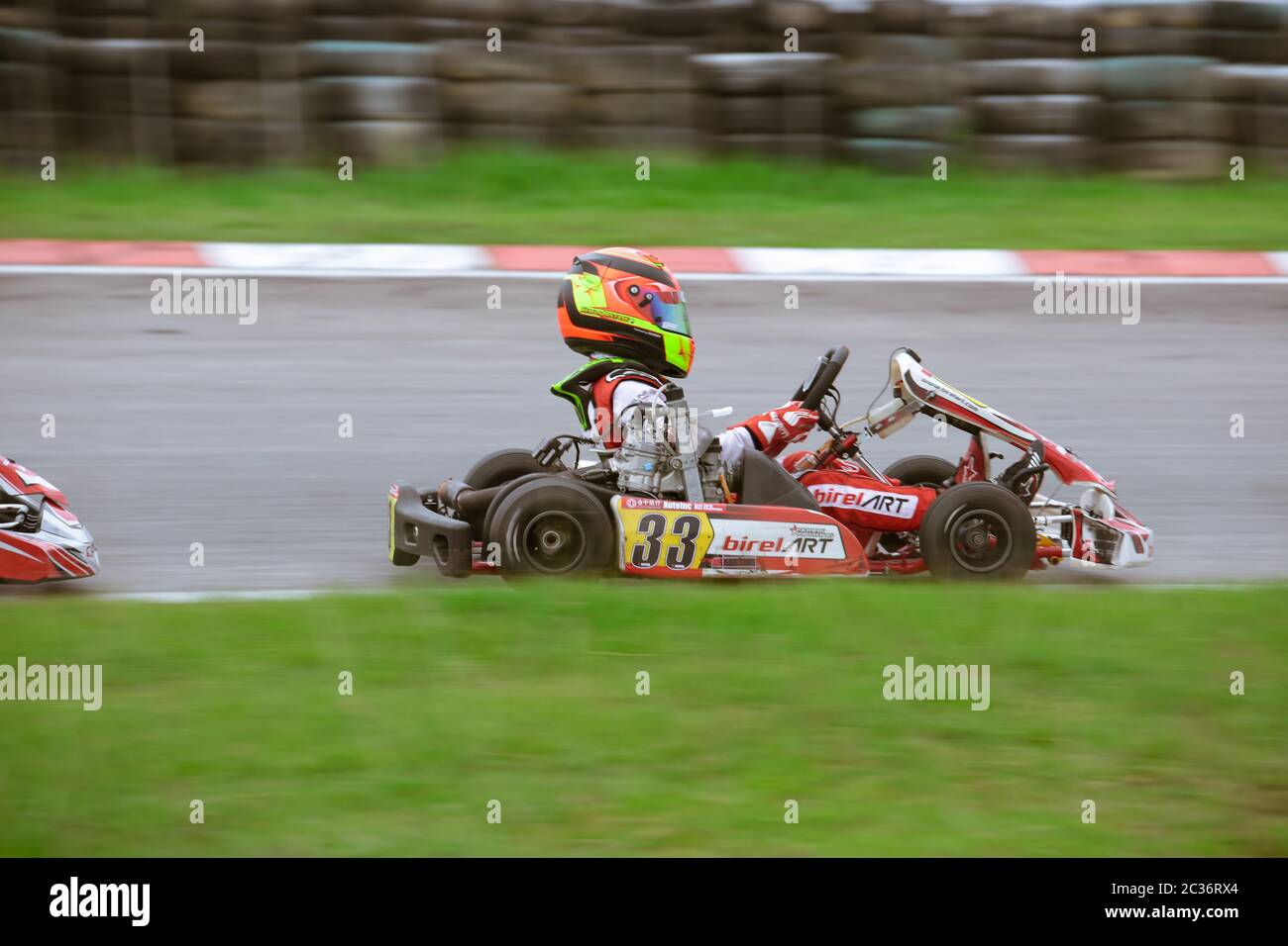 Kart racers speeding along a track corner Stock Photo - Alamy