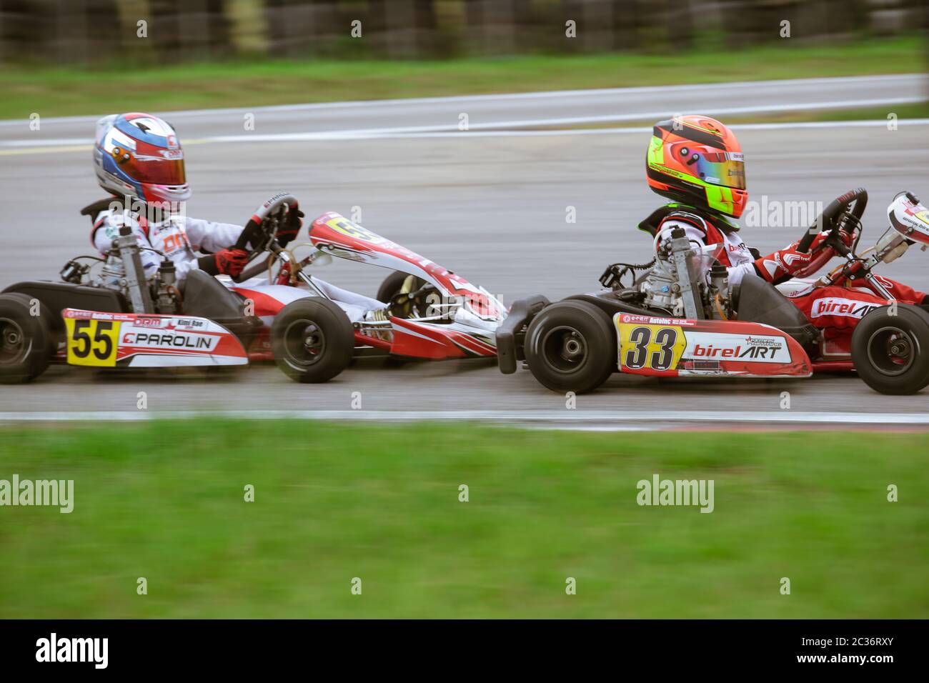 Kart racers speeding along a track corner Stock Photo - Alamy