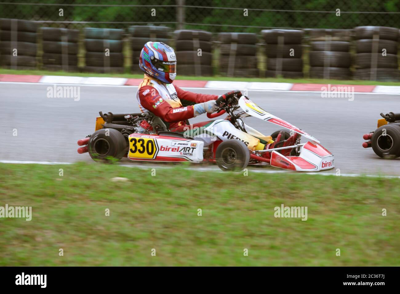 Kart racers speeding along a track corner Stock Photo - Alamy