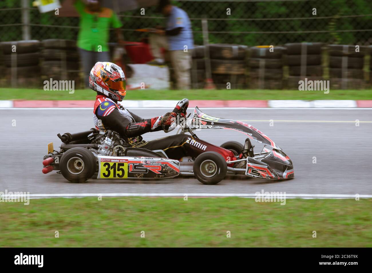 Kart racers speeding along a track corner Stock Photo - Alamy