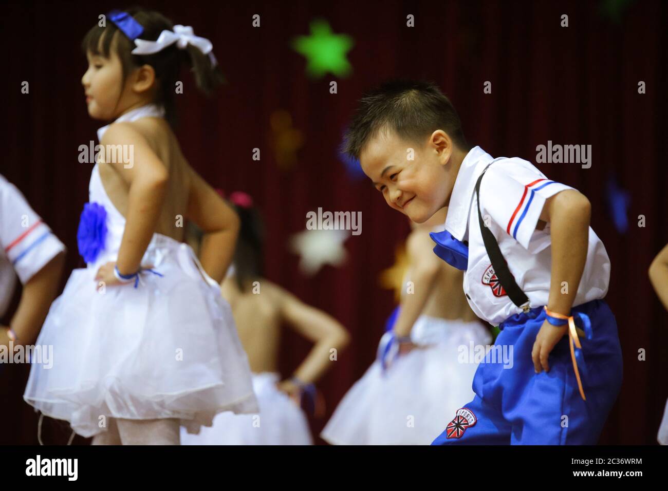 Kindergarten kids perform dance on stage during their year end ...