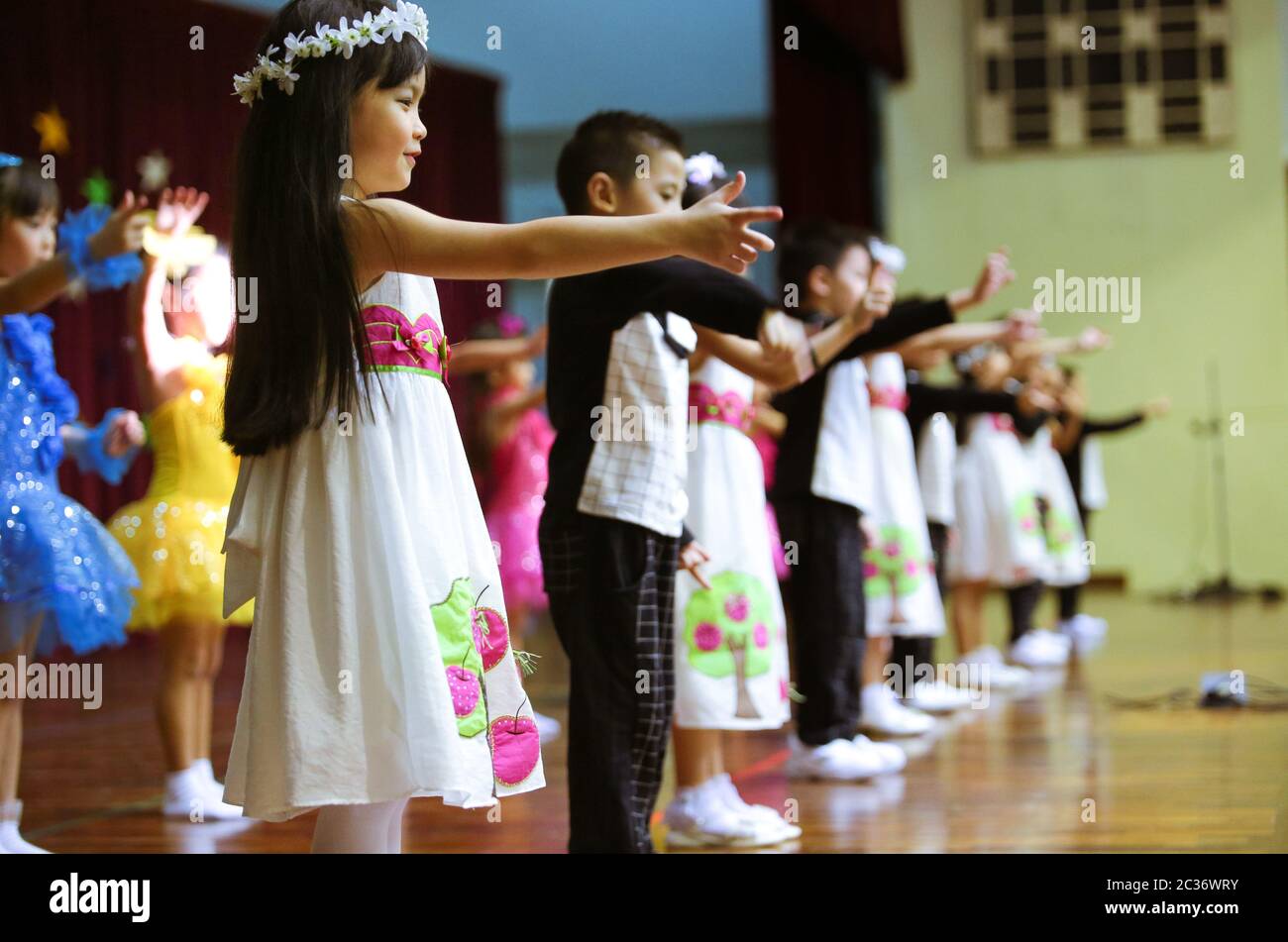 Kindergarten kids perform dance on stage during their year end ...