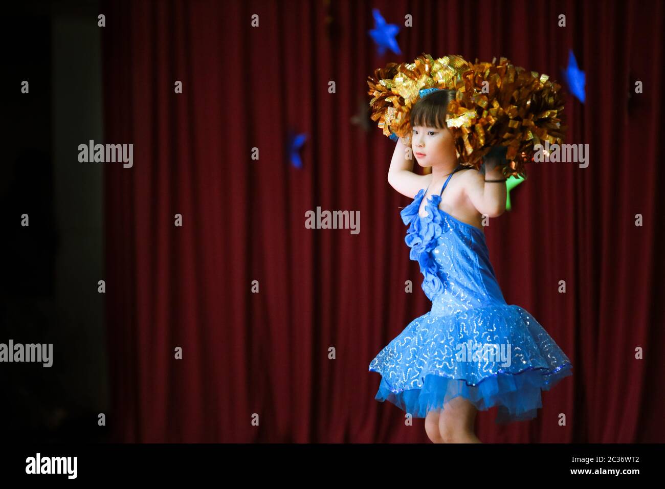 Kindergarten kids perform dance on stage during their year end ...