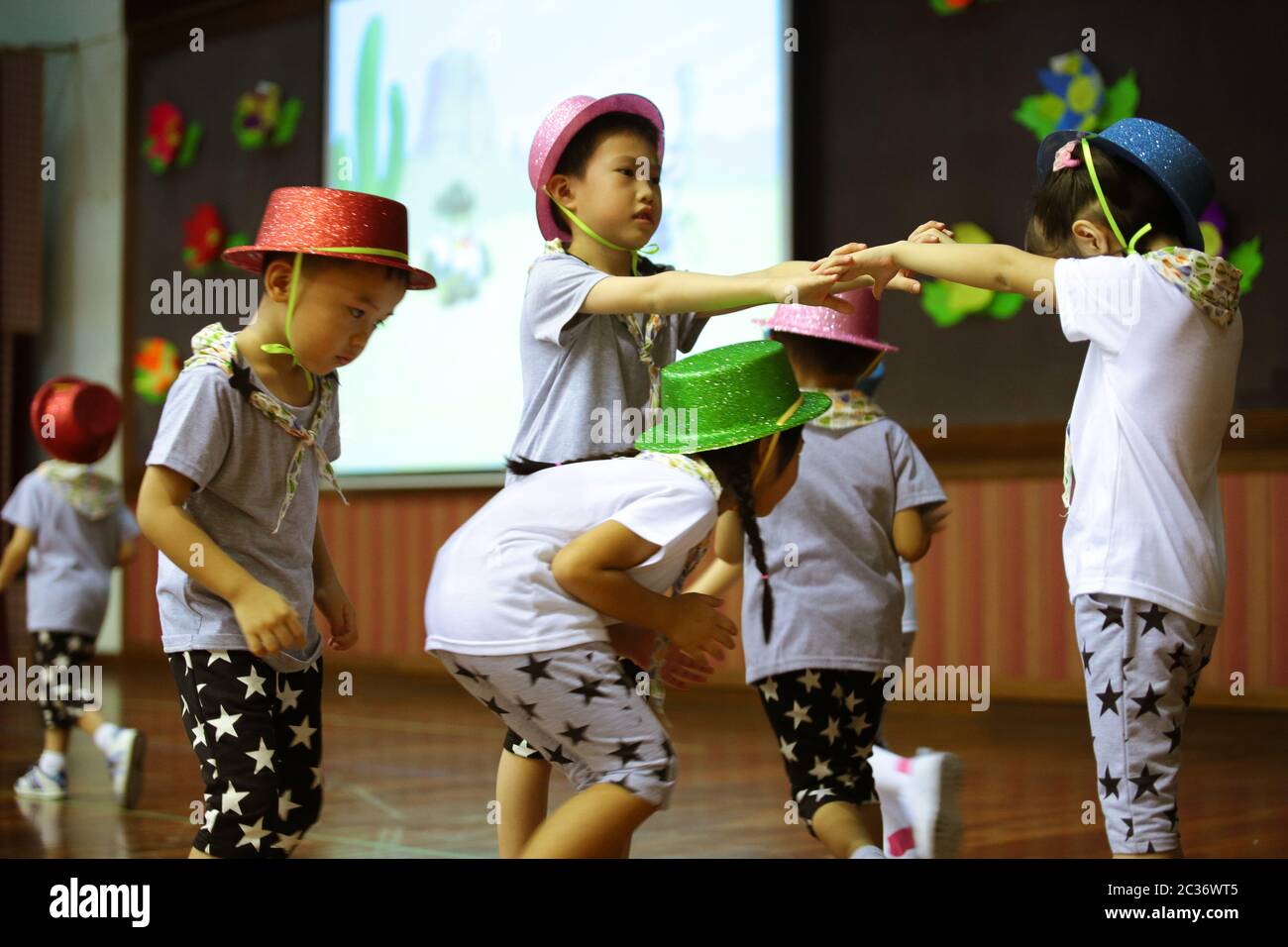 Kindergarten kids perform dance on stage during their year end ...