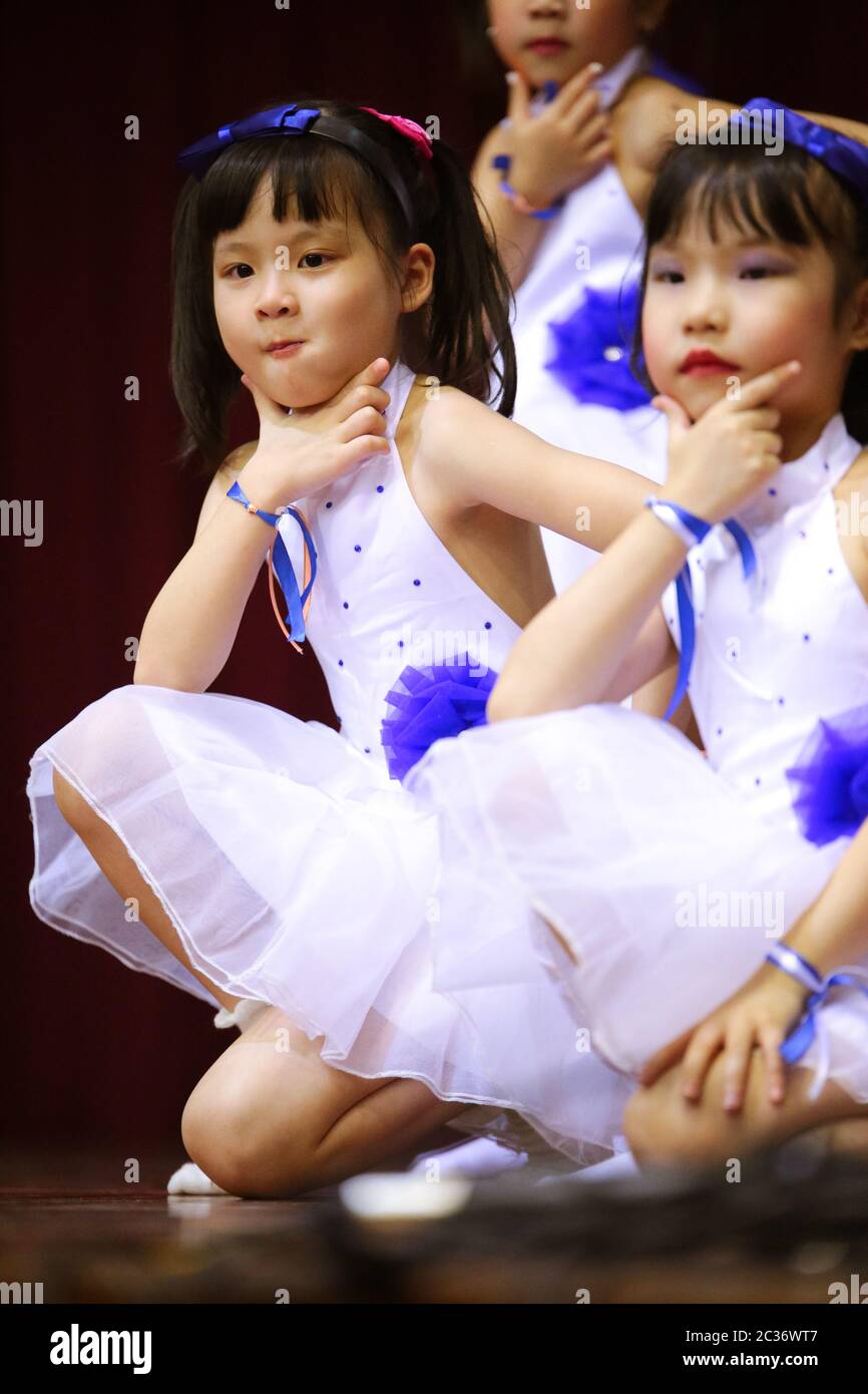 Kindergarten kids perform dance on stage during their year end ...