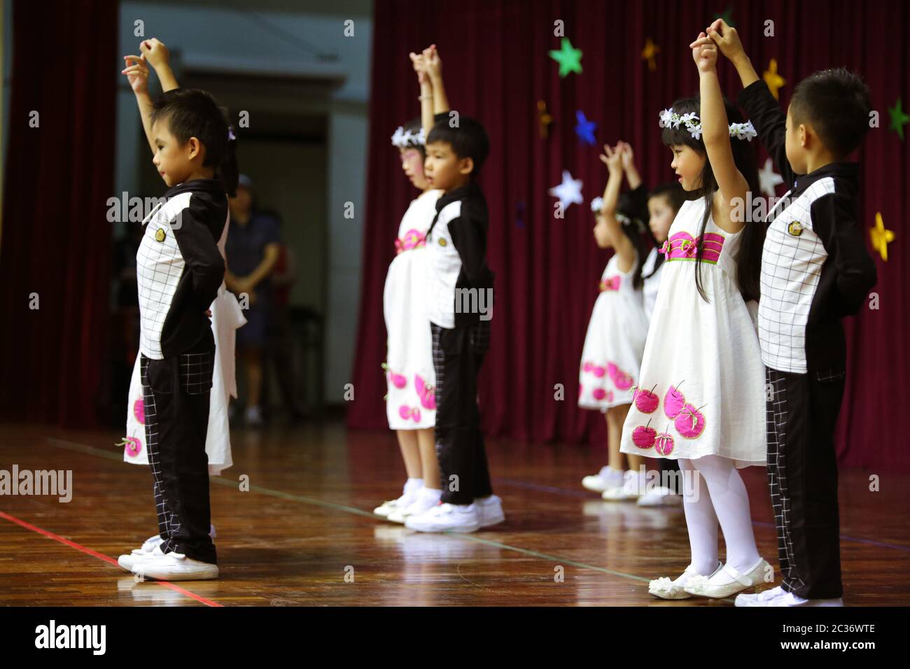Kindergarten kids perform dance on stage during their year end ...
