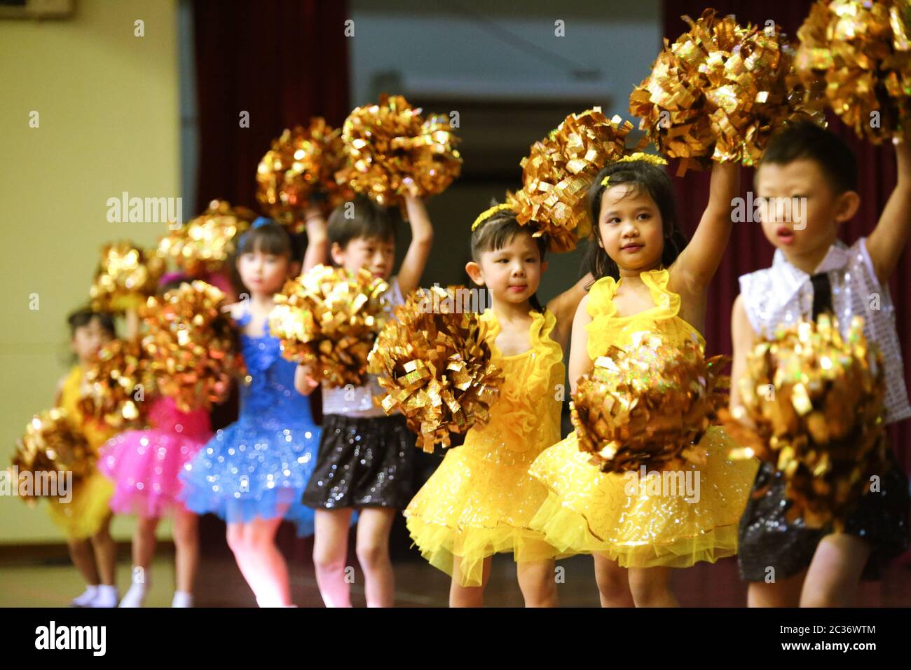 Kindergarten kids perform dance on stage during their year end ...
