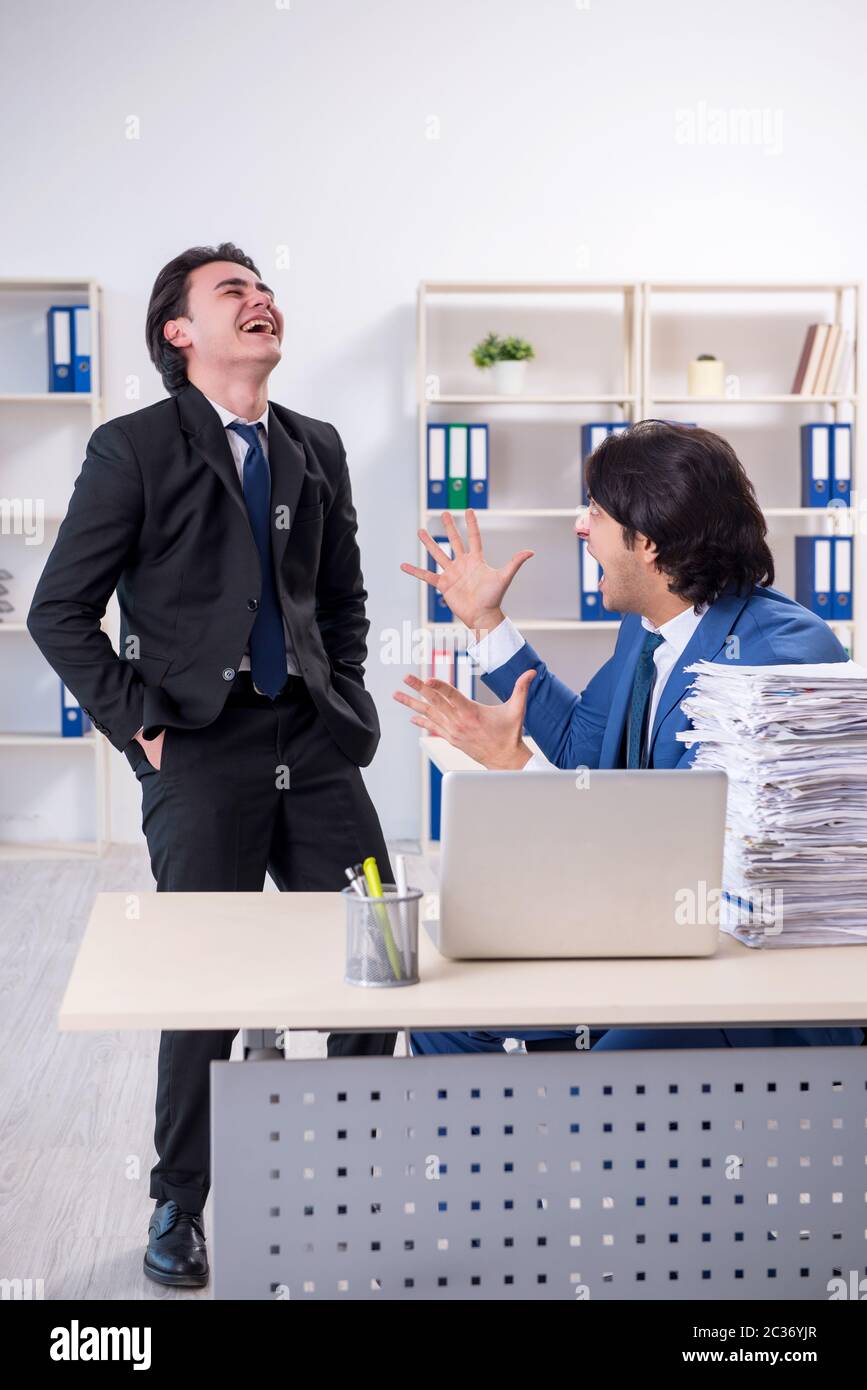 Two male colleagues unhappy with excessive work Stock Photo - Alamy