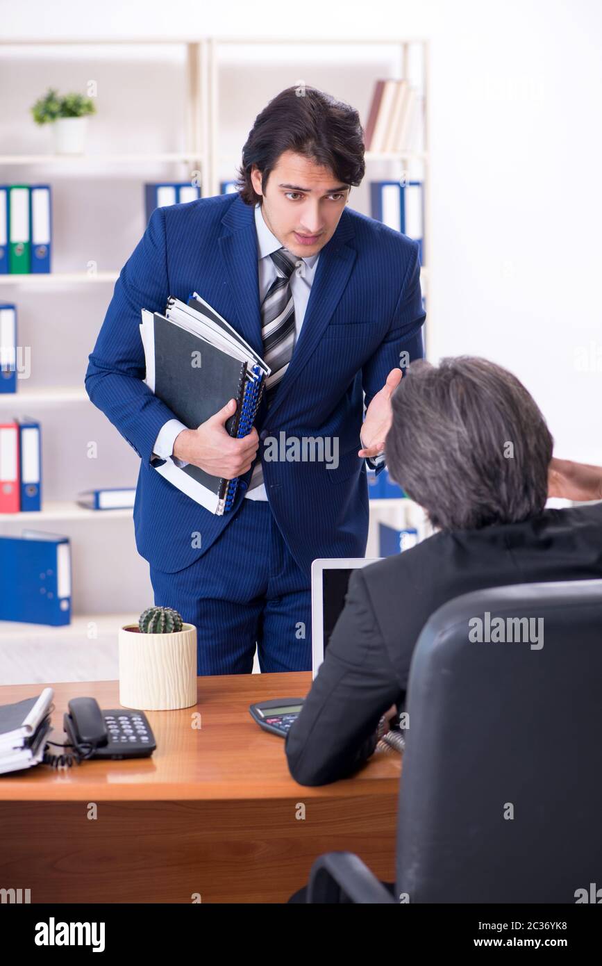 Boss and his male assistant working in the office Stock Photo - Alamy