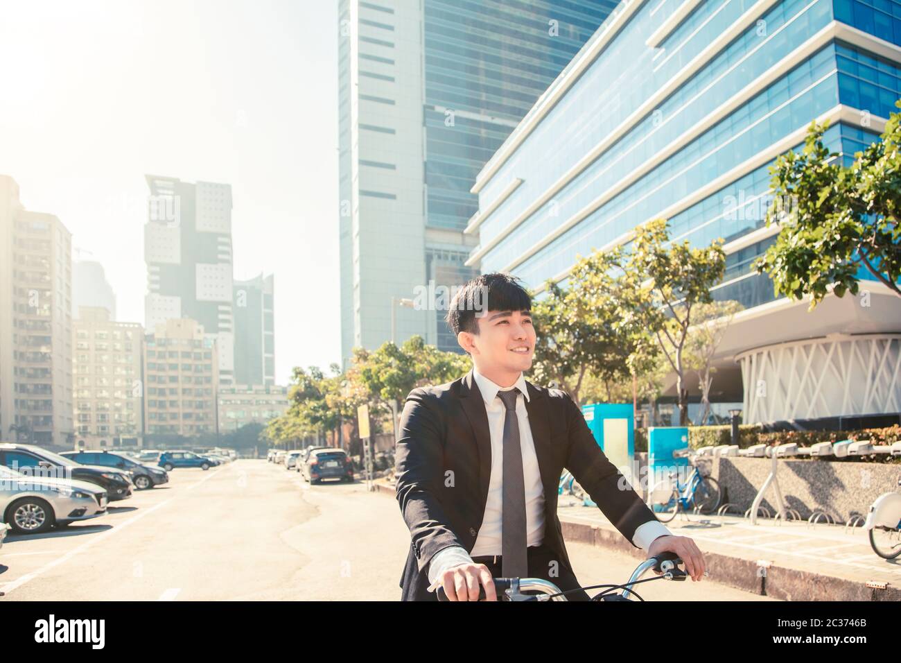 Businessman riding bicycle to work on urban street at morning Stock ...