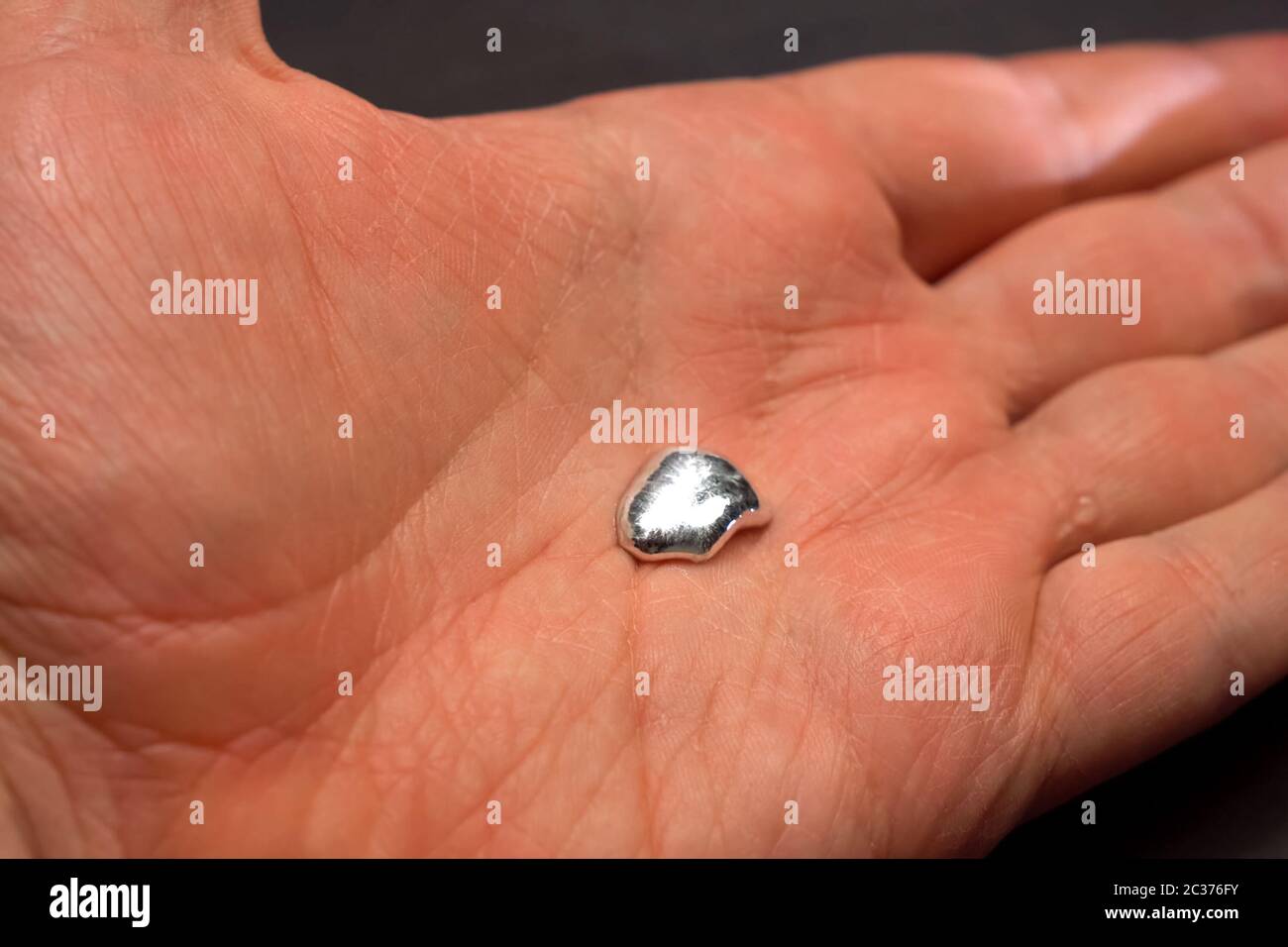 liquid metal in the hands of a man. fusible metal Stock Photo - Alamy