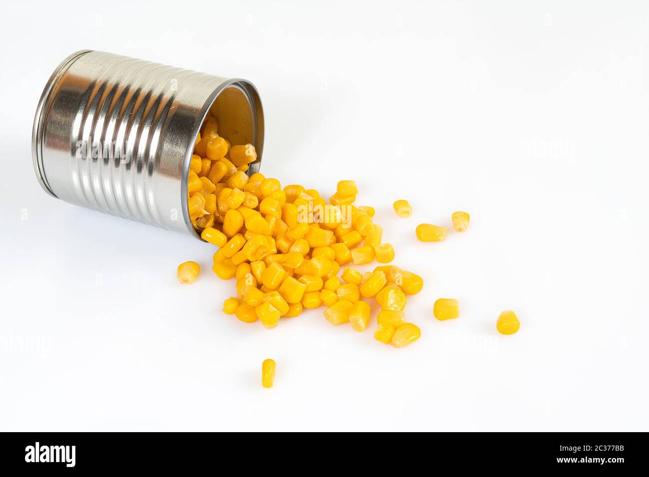 a tin of corn spilled on a white surface Stock Photo - Alamy