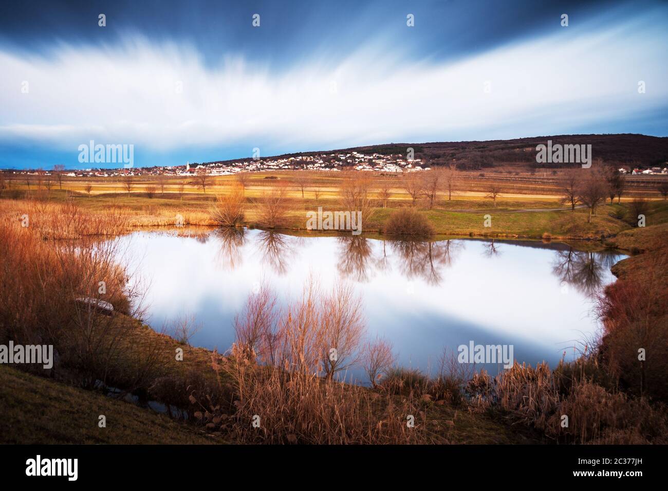 Small pond with reed and moving clouds in the sky Stock Photo - Alamy