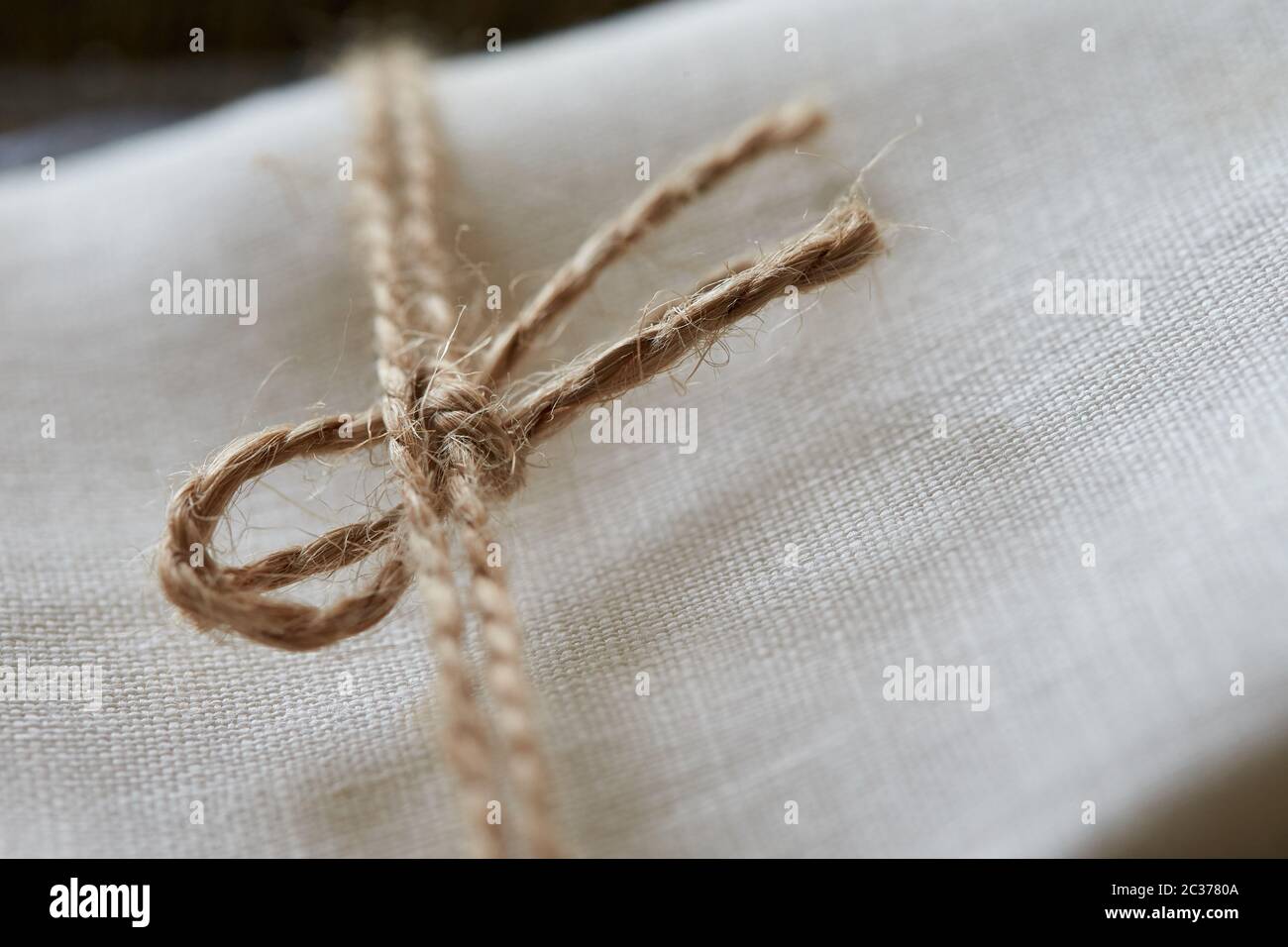 Twine tied in a bow. Close-up. Fabric background Stock Photo - Alamy