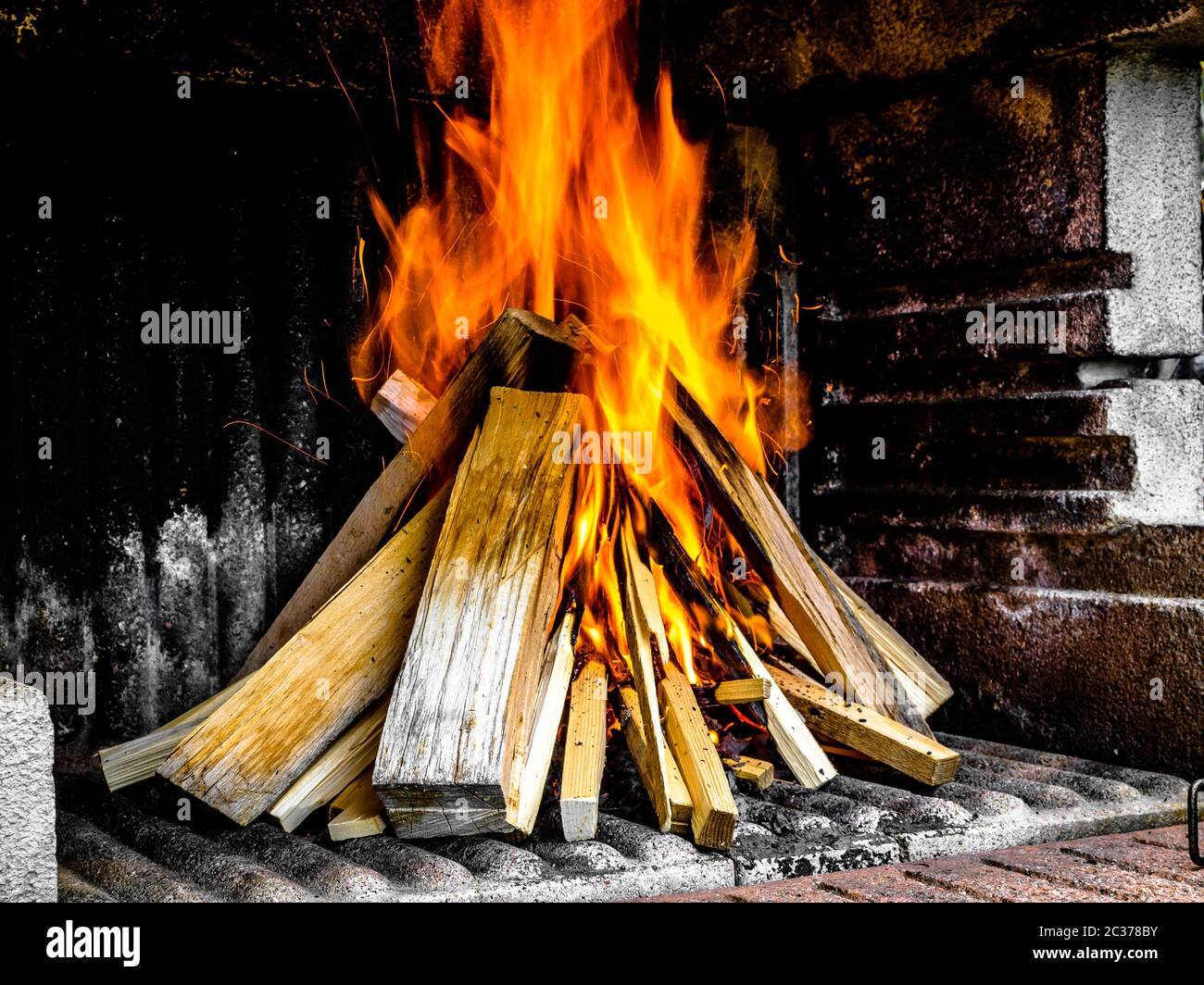 Preparation of a BBQ - wood piled up - fire reaching top of the pile ...