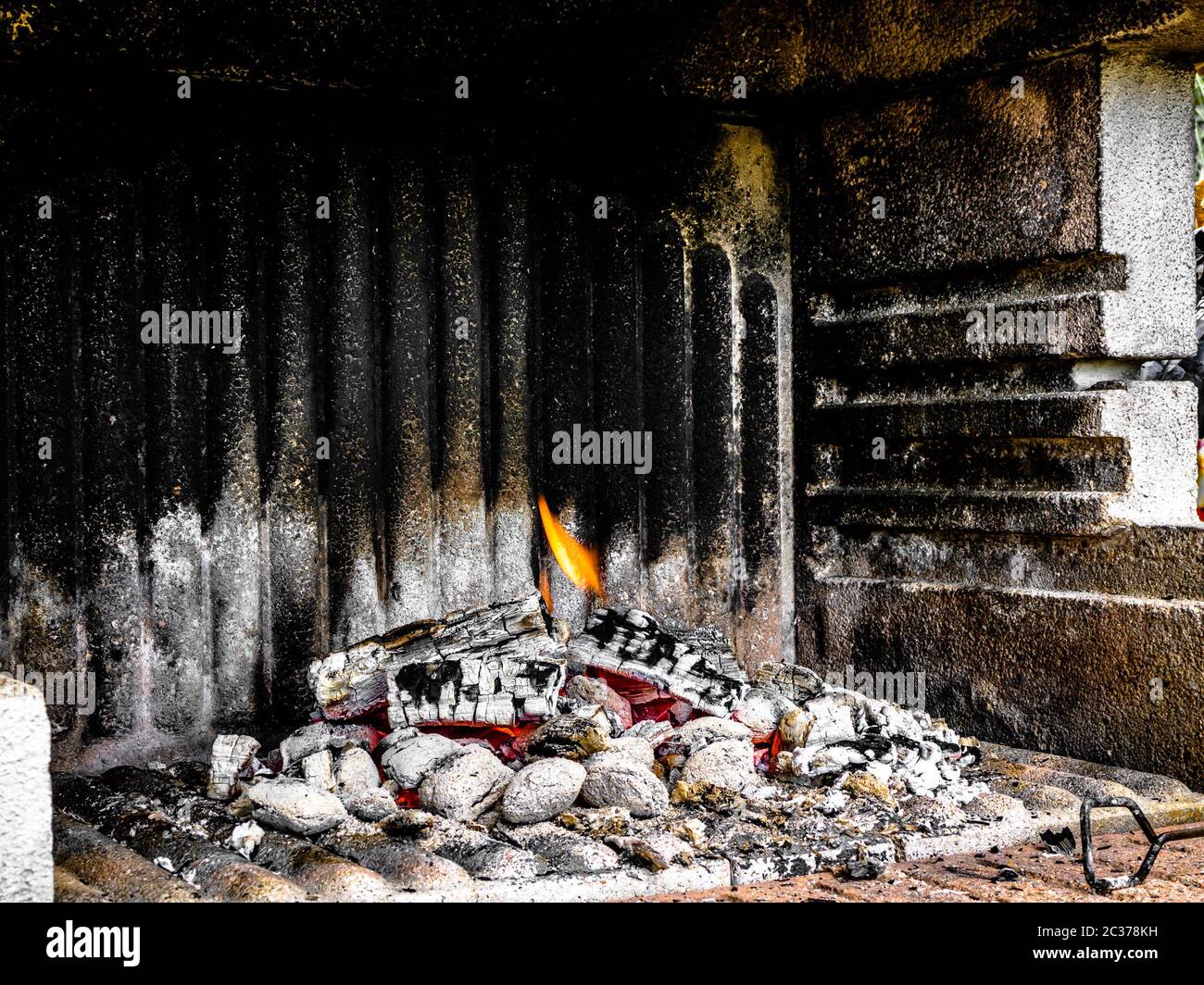 Firewood almost burnt down in a concrete grill - charcoal briquettes ...