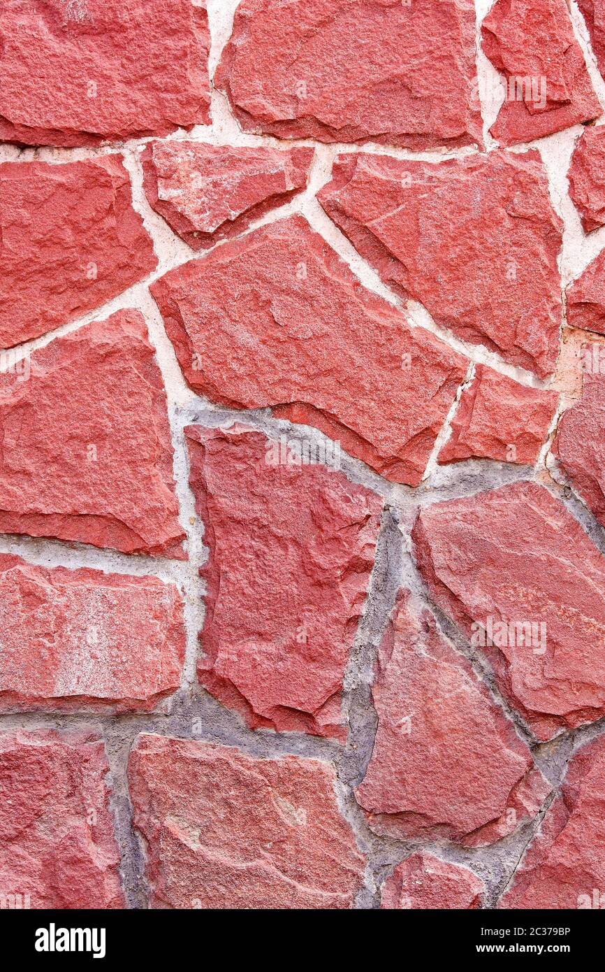 Wall made from natural rough red stones Stock Photo - Alamy