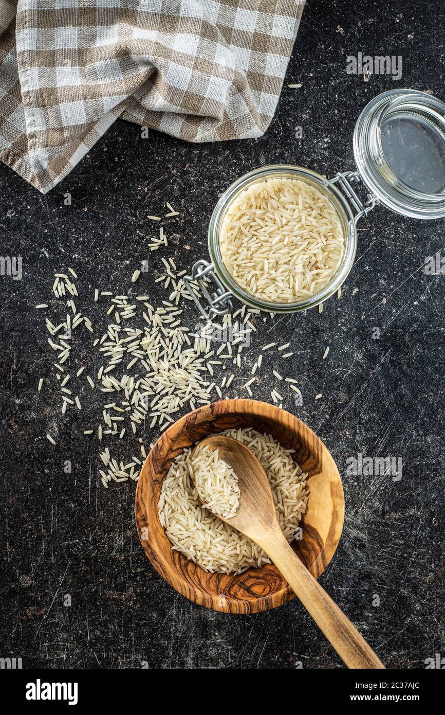 Uncooked indian long rice on old kitchen table. Top view Stock Photo ...