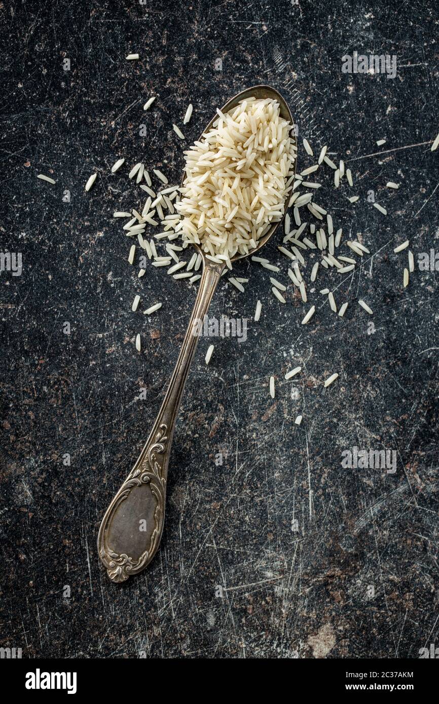 Uncooked indian long rice in spoon. Top view Stock Photo - Alamy