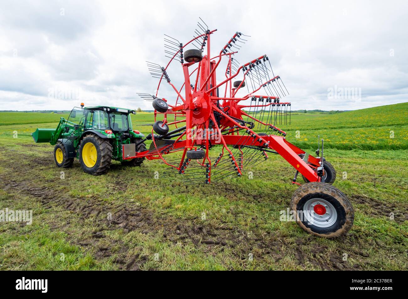 The tractor with new hay tedder standing in the field Stock Photo - Alamy