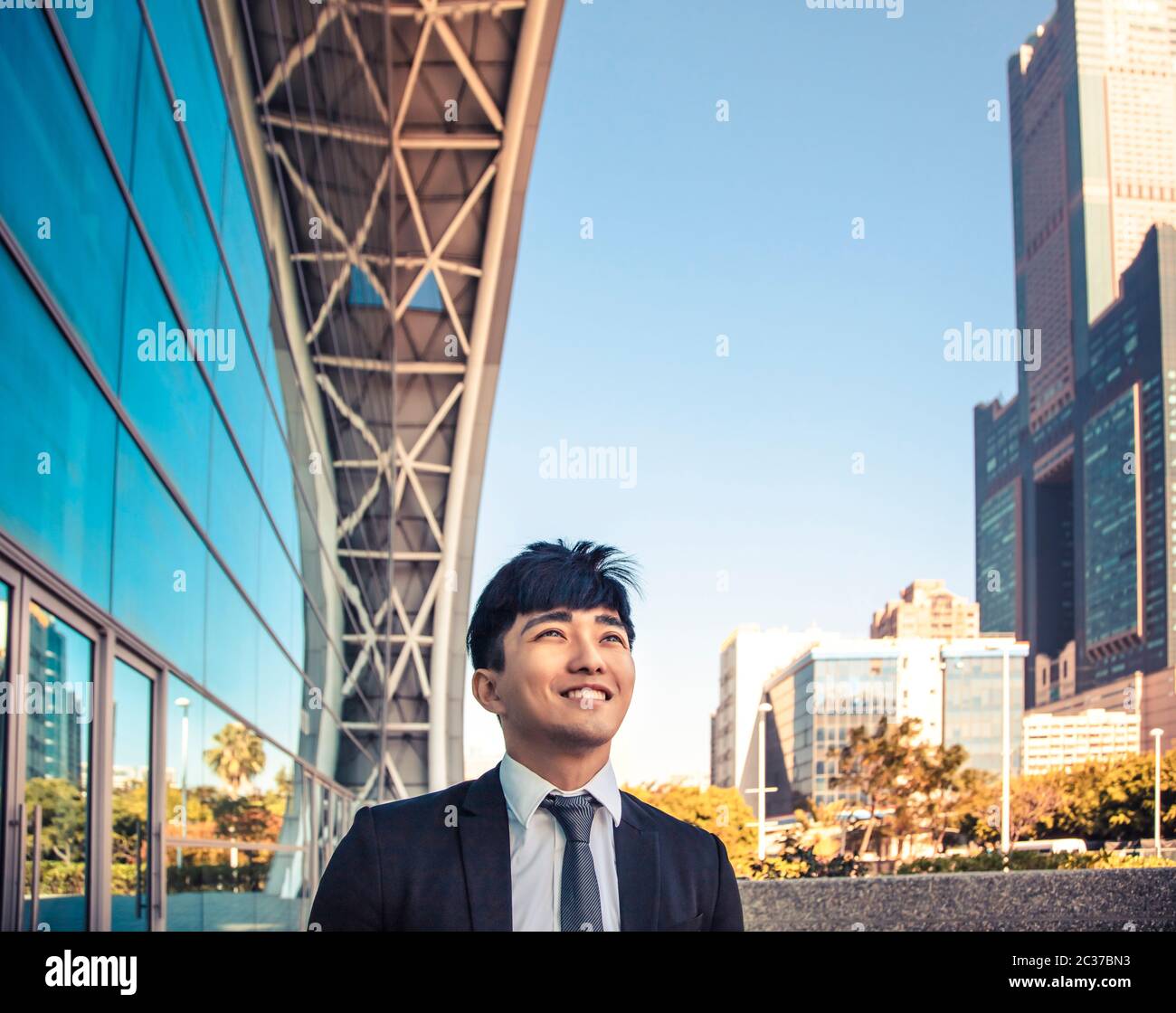 Businessman standing in front skyscraper hi-res stock photography and ...