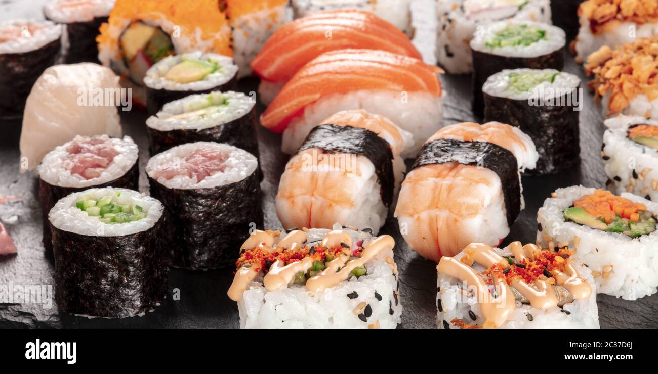 Large sushi set panorama, close-up. An assortment of various maki ...