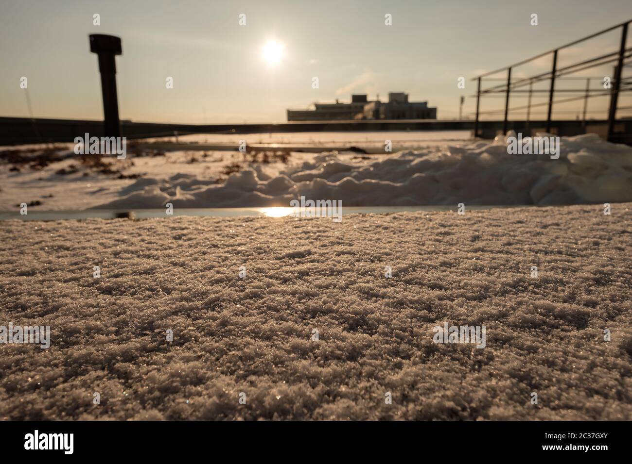 Snow crystals in back lit sun on building roof Stock Photo - Alamy