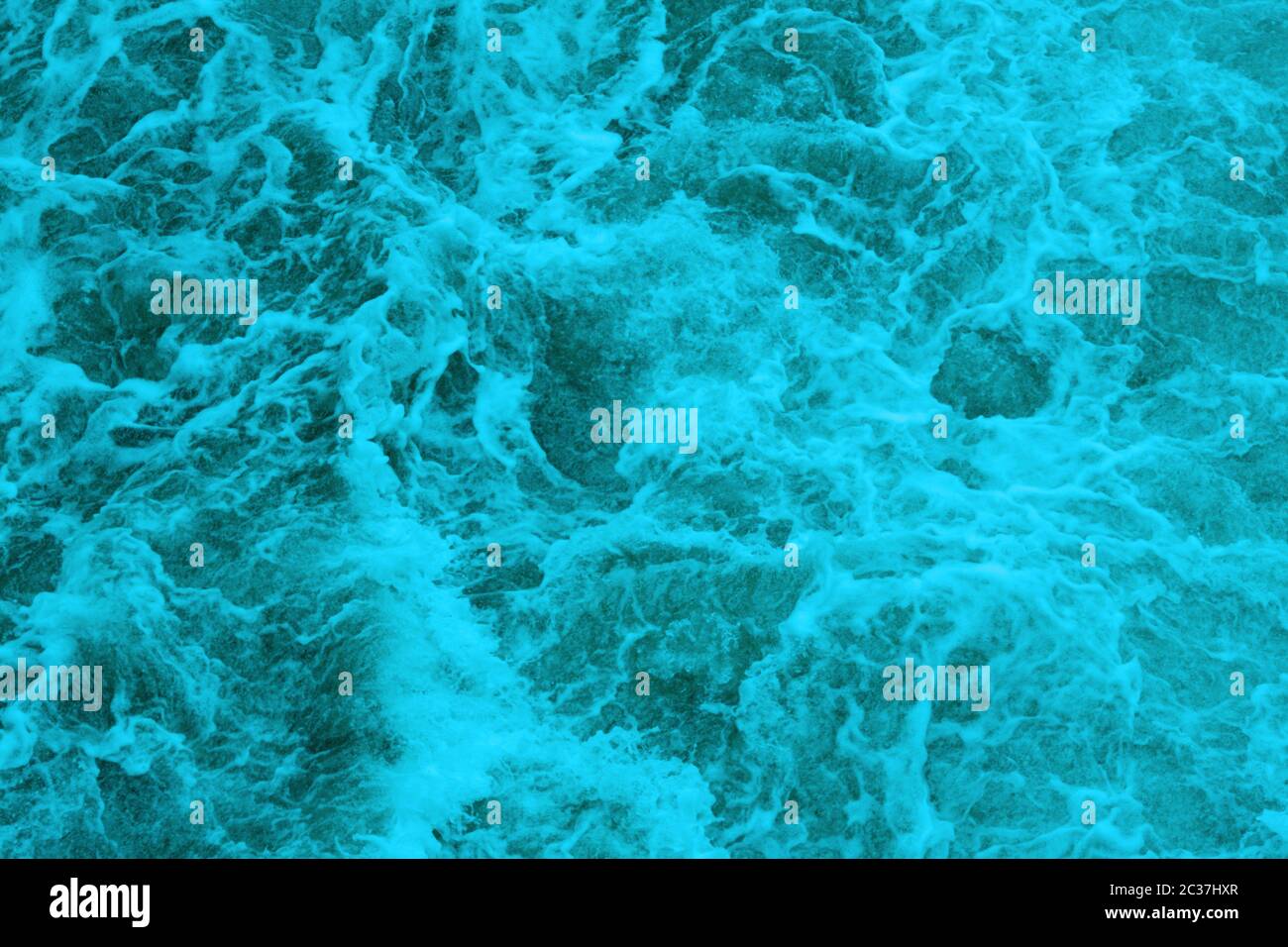 Vibrant fast moving blue water with foam Stock Photo - Alamy