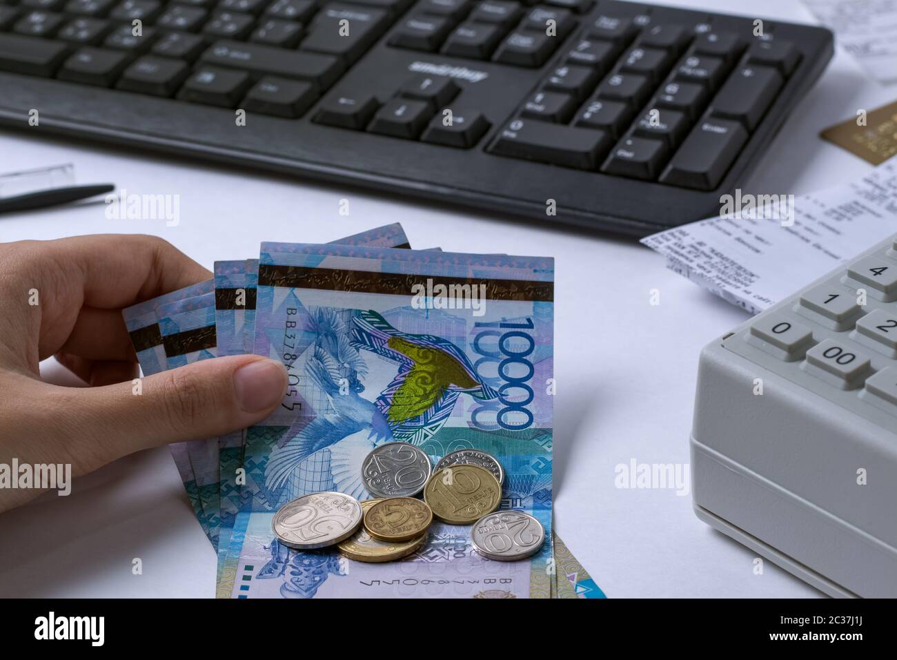 Tenge at the cashier accountant in the hands of the workplace in the ...
