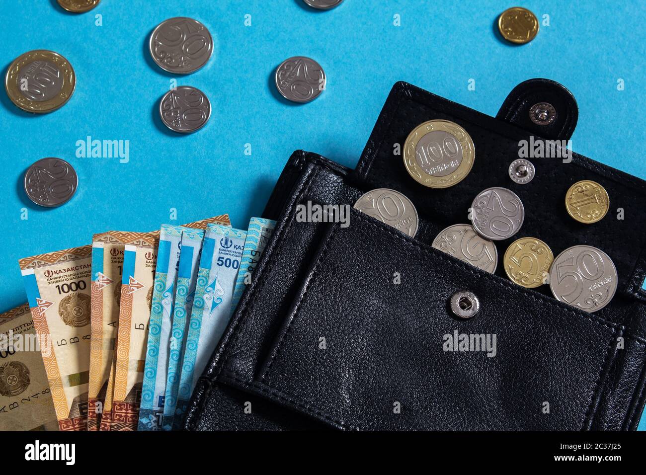 Tenge on blue background with coins. Tenge is the national currency of ...