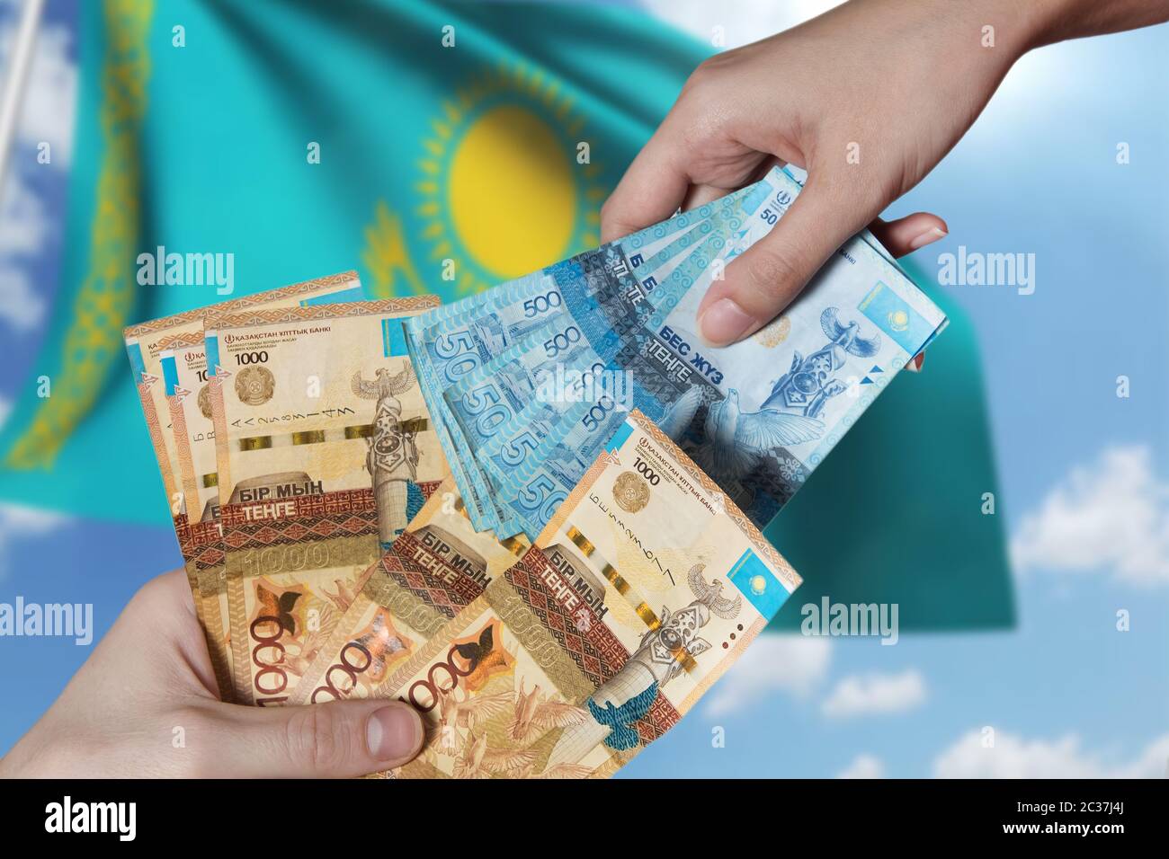 Paper banknotes tenge KZT people hold in their hands on the background ...