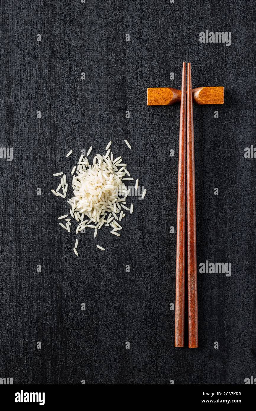 Uncooked indian long rice and chopsticks. Top view Stock Photo - Alamy