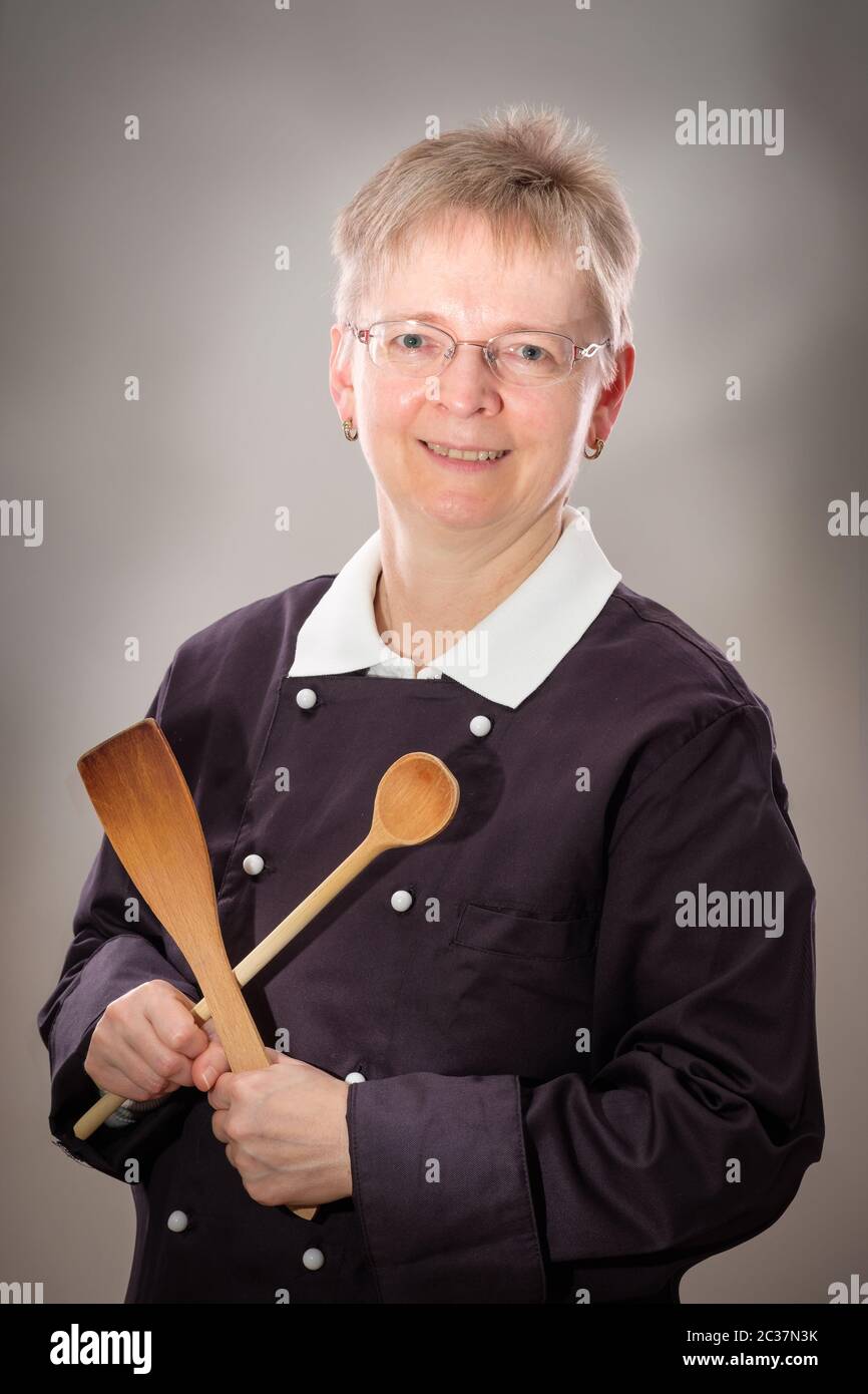 Female chef smiling with wooden cooking spoon Stock Photo - Alamy