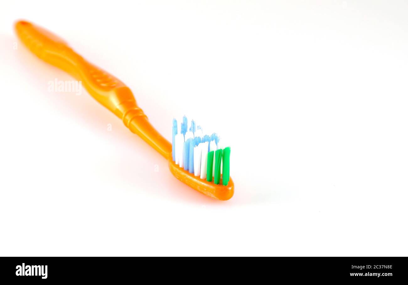 Orange toothbrush over neutral Stock Photo - Alamy