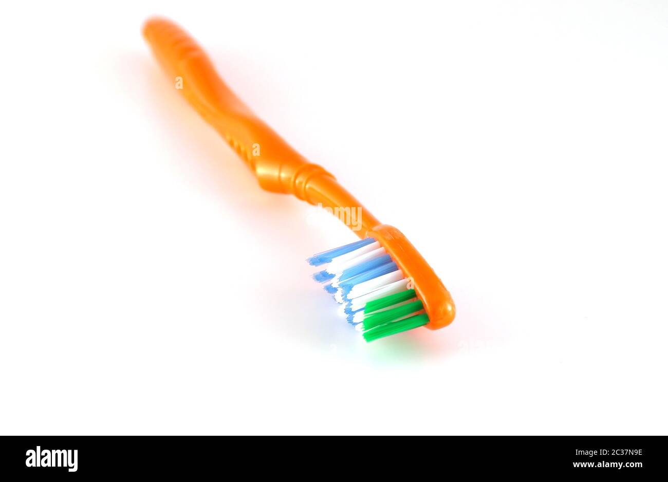 Orange toothbrush over neutral Stock Photo - Alamy