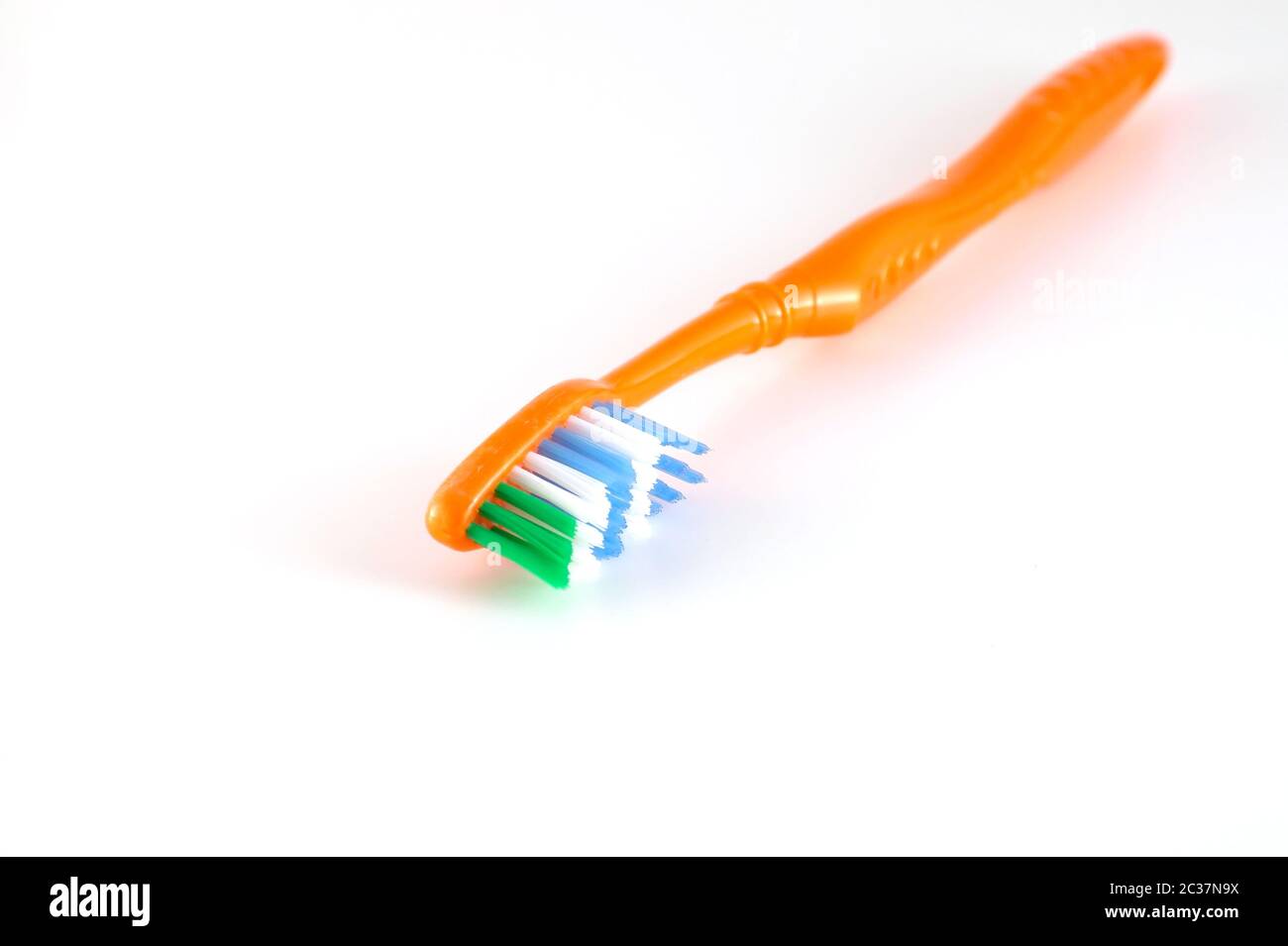 Orange toothbrush over neutral Stock Photo - Alamy