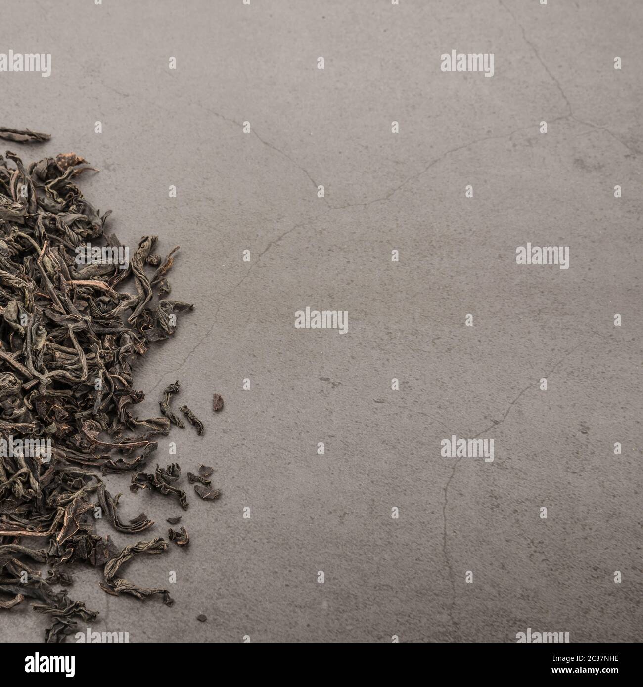 Dried tea is poured scattered on a grey textured background Stock Photo ...