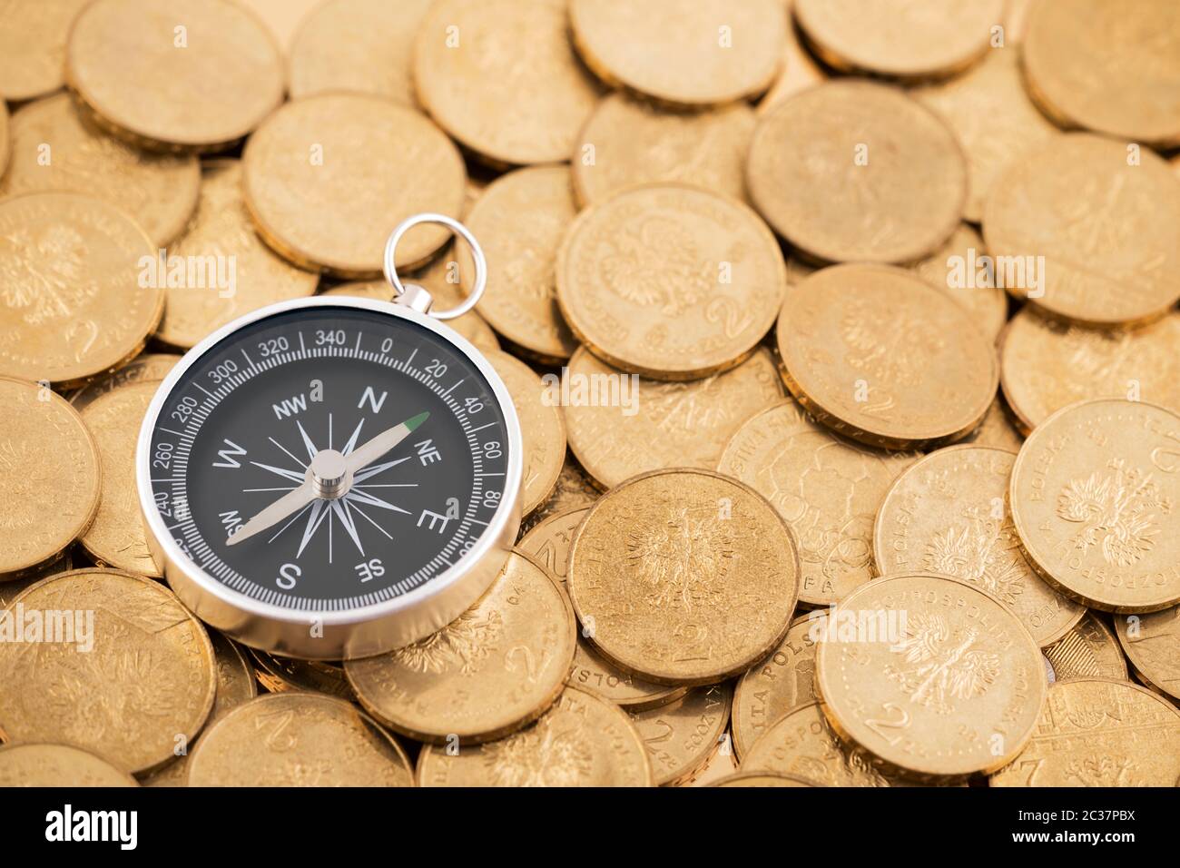 Financial concept with coins and compass Stock Photo - Alamy