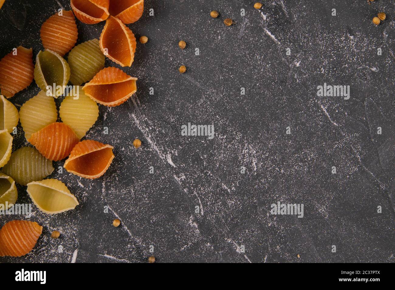 Pasta Conchiglie Rigate, mix of colorful uncooked shells scattered on ...