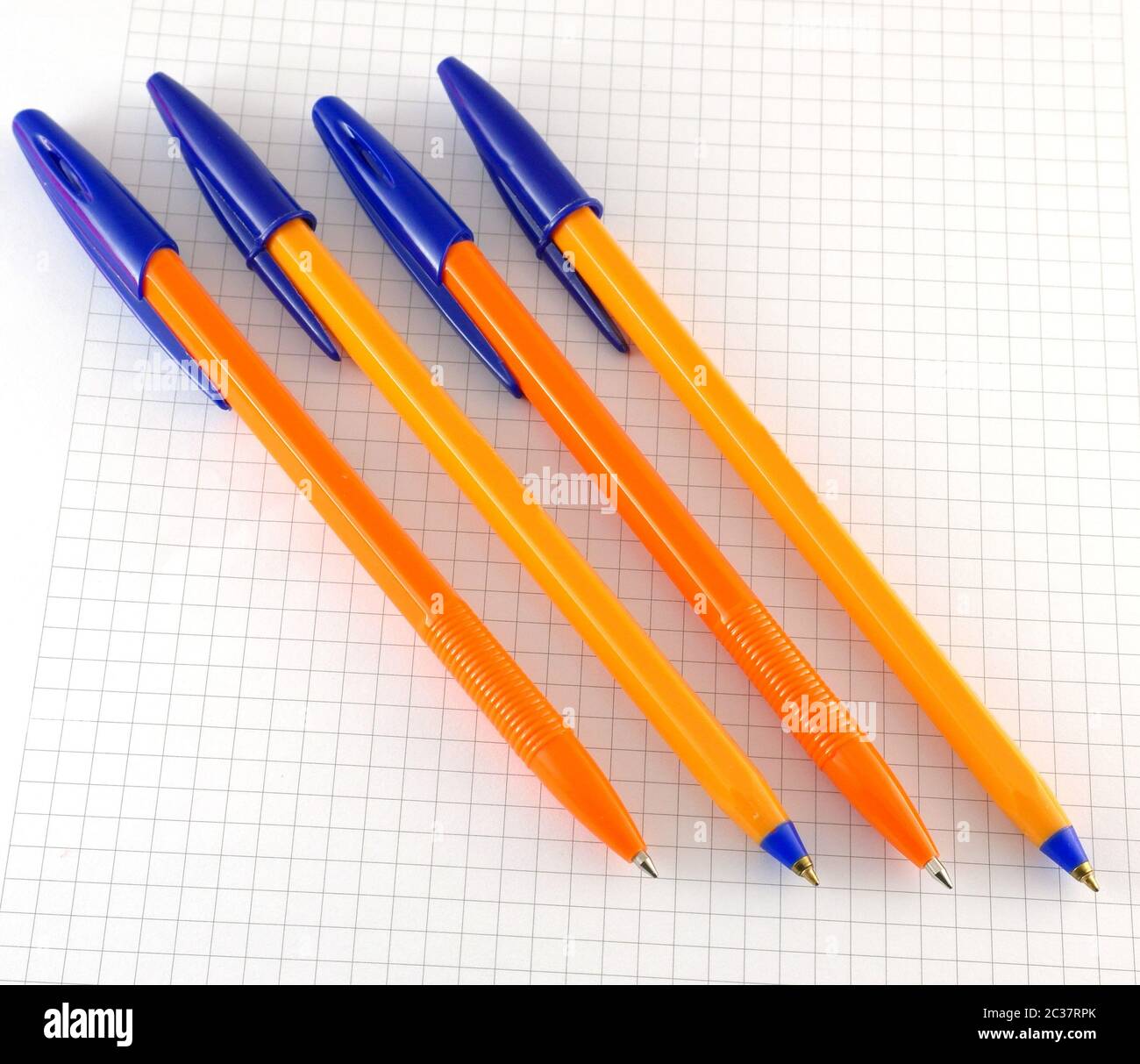 Four pen on the checked paper of notepad Stock Photo - Alamy