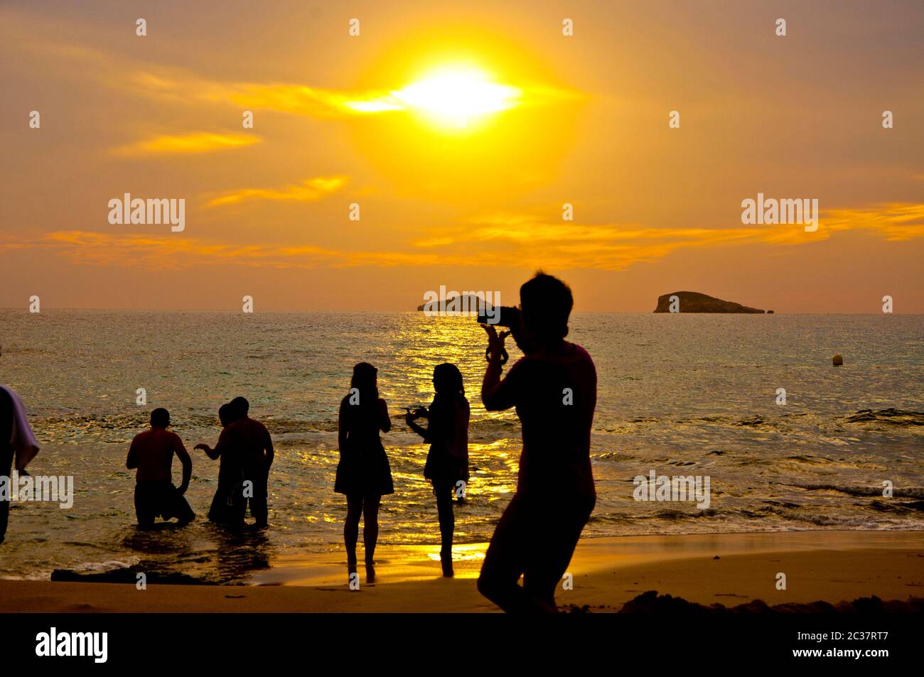 People watching the sunset at BenirrÃ¡s Beach, Ibiza Island. Boats ...